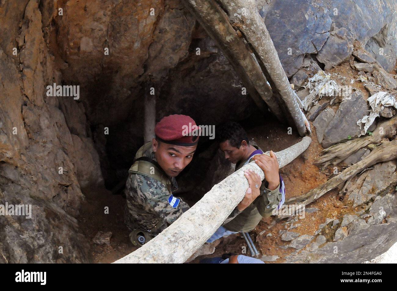 A soldier stands guard at the entrance of a collapsed gold mine where ...