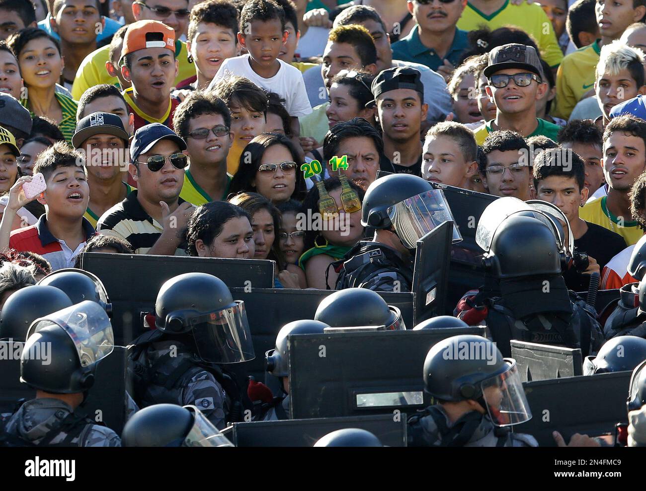 Soccer fans gather outside the stadium as police in riot gear protect ...