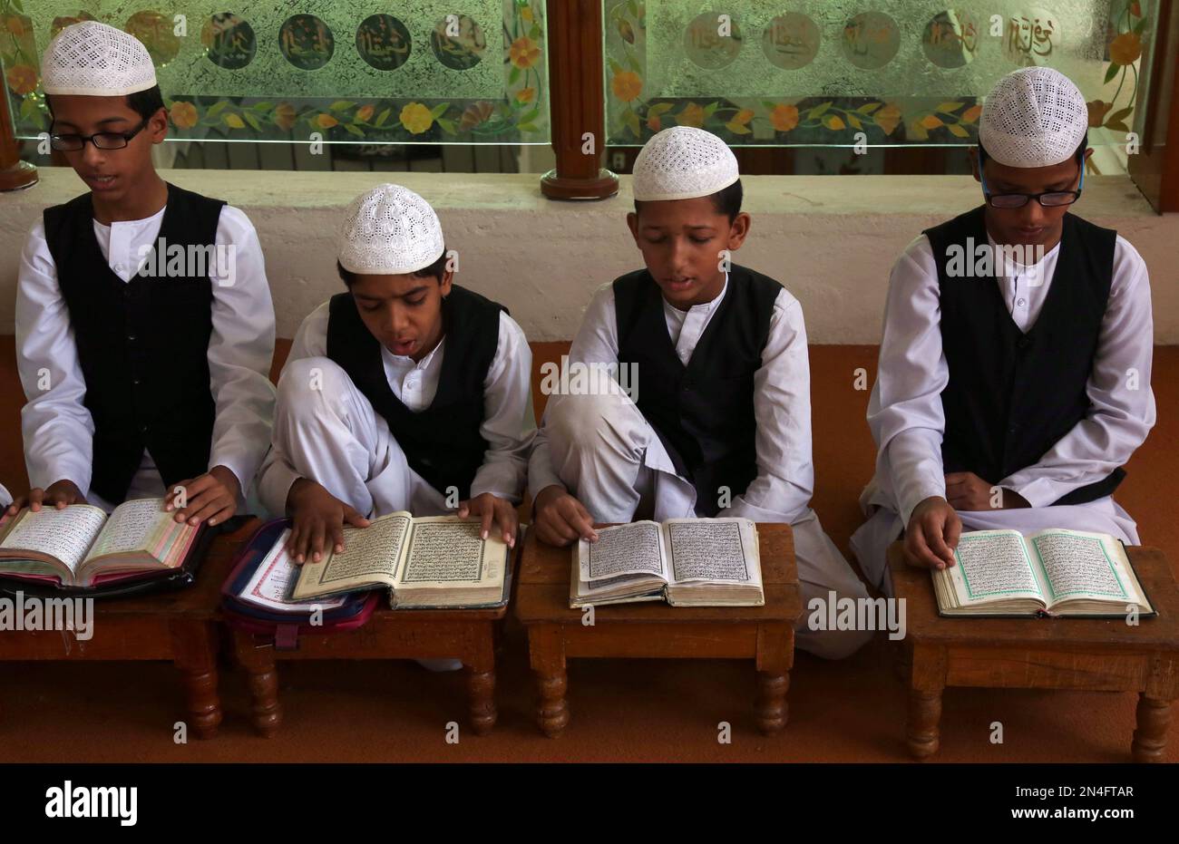 Indian Muslim children read the Quran during the holy month of Ramadan at a madrasa, or ...