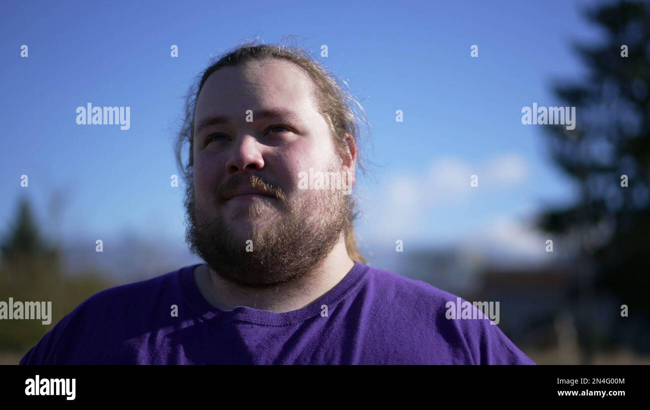 One pensive happy young man walking forward outside smiling. A joyful ...