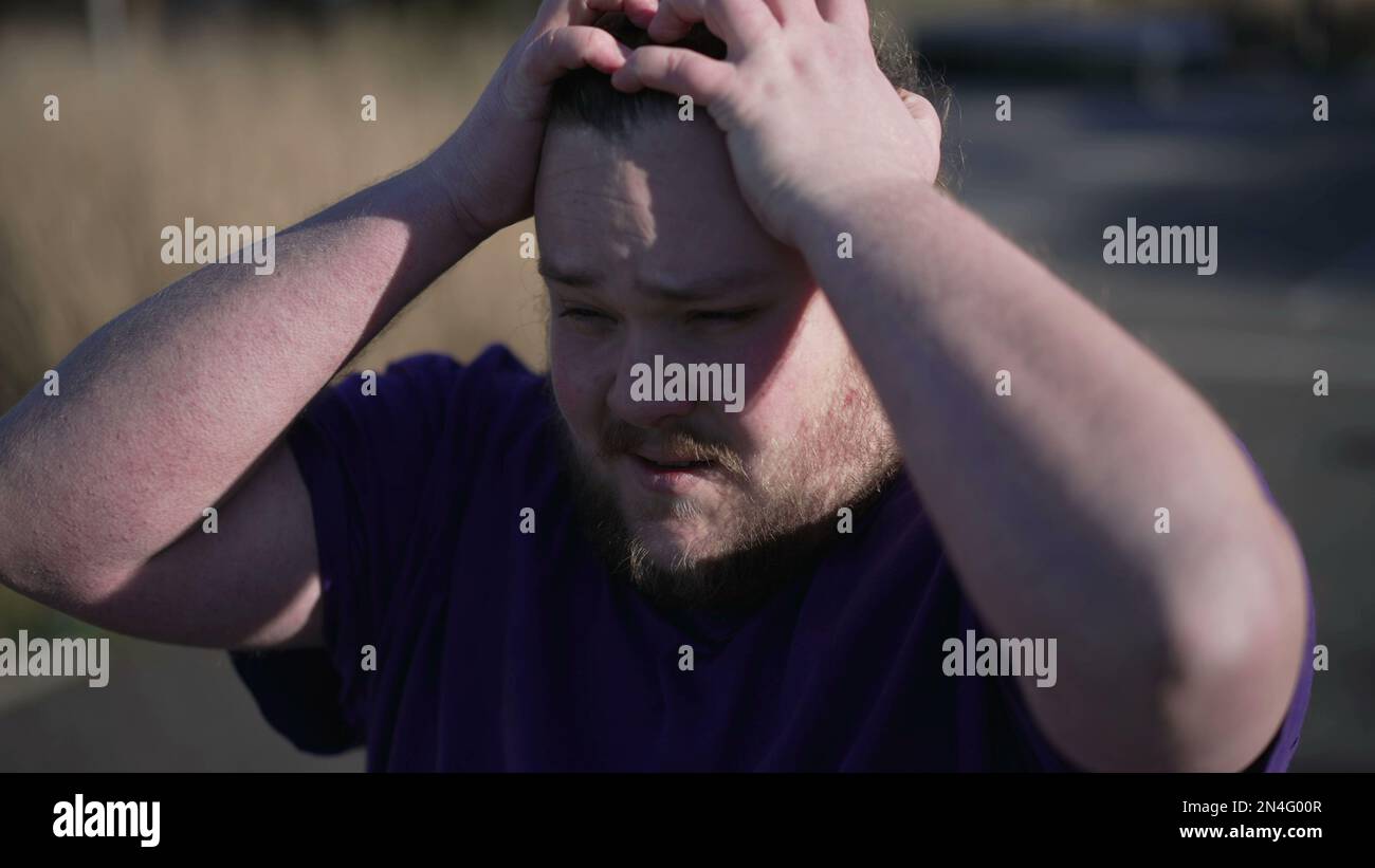One stressed overweight young man feeling frustration outside in street ...
