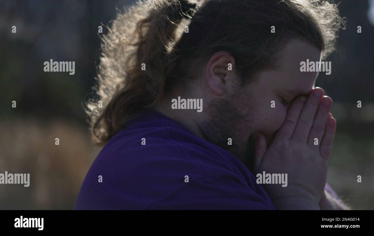 One young man praying to God during hard times. Faithful person in ...