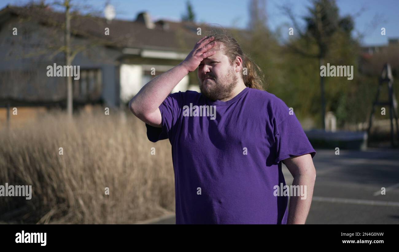 One frustrated overweight young man standing outdoors feeling regret ...
