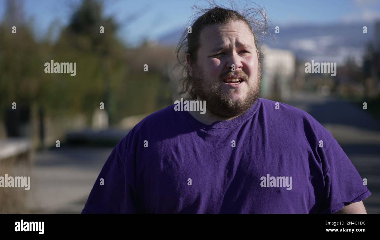 One frustrated overweight young man standing outdoors feeling regret ...