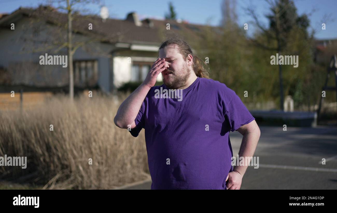 One frustrated overweight young man standing outdoors feeling regret ...