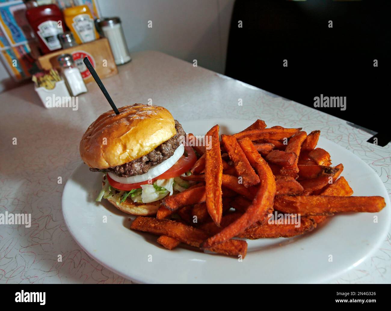This June 11, 2014 photo shows an Arrow burger with sweet potato fries ...