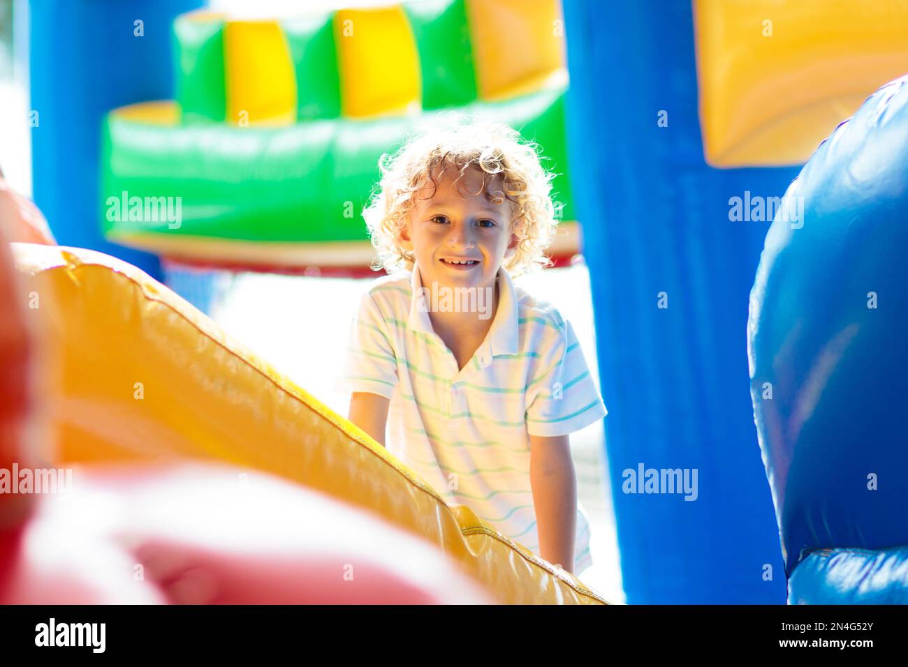 Child jumping on colorful playground trampoline. Kids jump in ...
