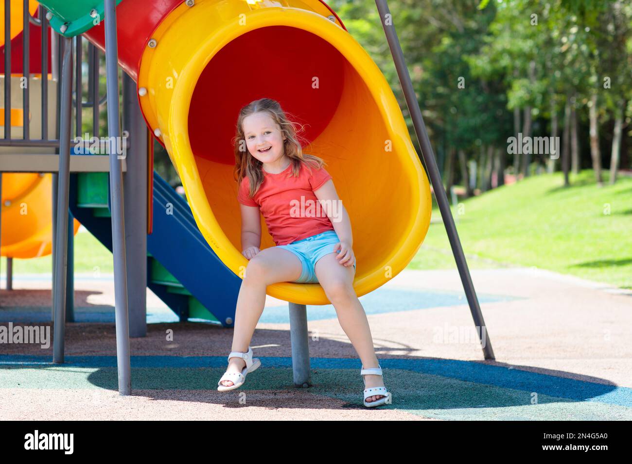 Kids climbing and sliding on outdoor playground. Children play in sunny ...