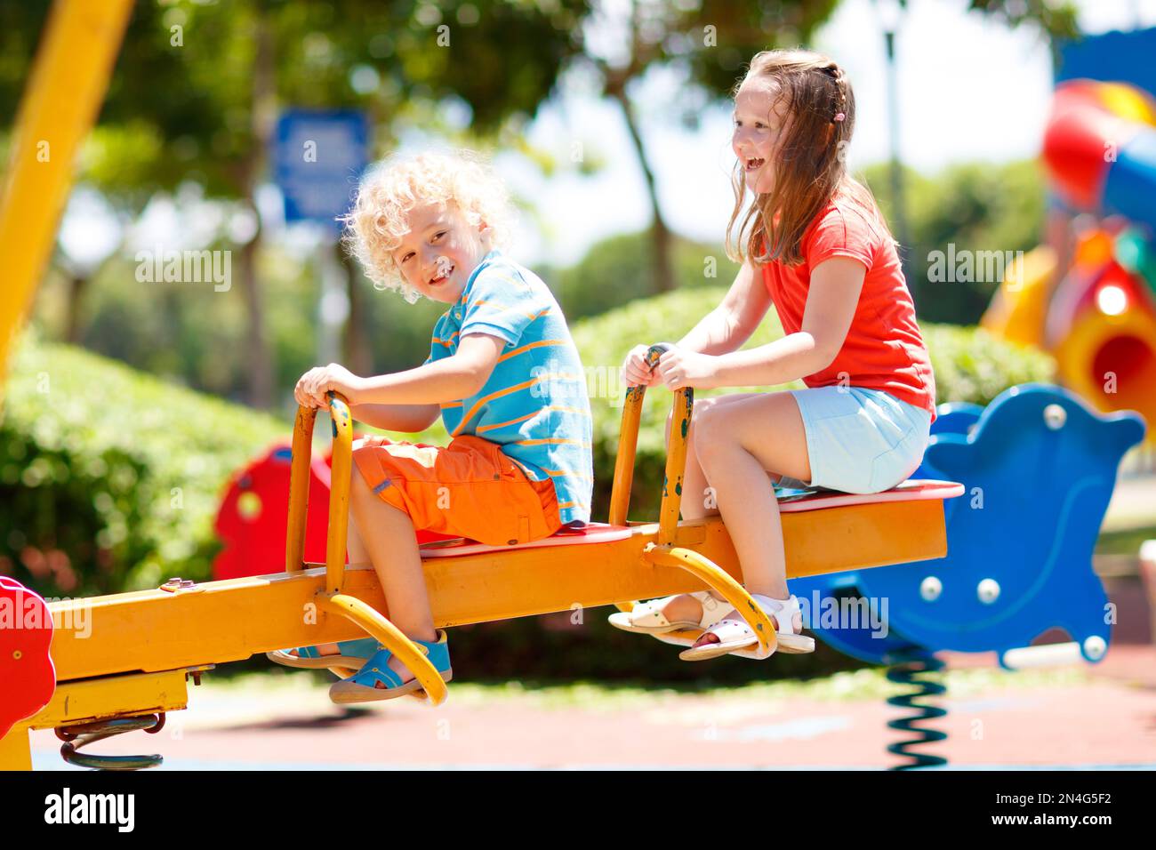 Kids climbing and sliding on outdoor playground. Children play in sunny ...