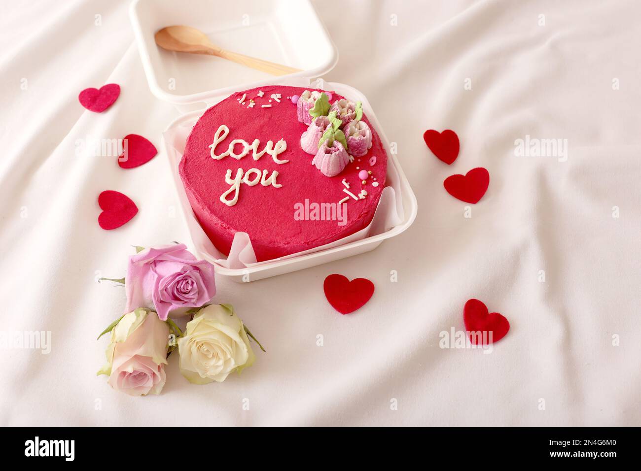 Plastic lunch box with tasty red bento cake lie on white bed Stock ...