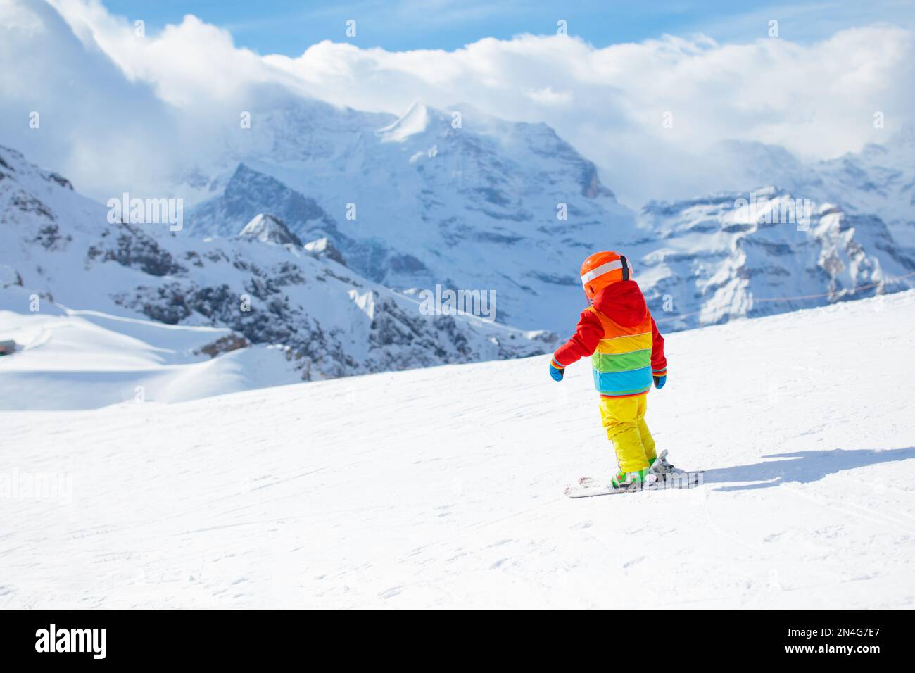 Child skiing in the mountains. Kid in ski school. Winter sport for kids. Family Christmas ...