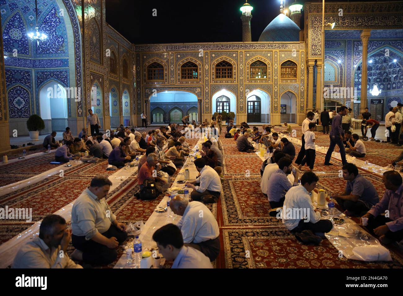 Iranians attend an Iftar, the evening meal in which Muslims break their ...