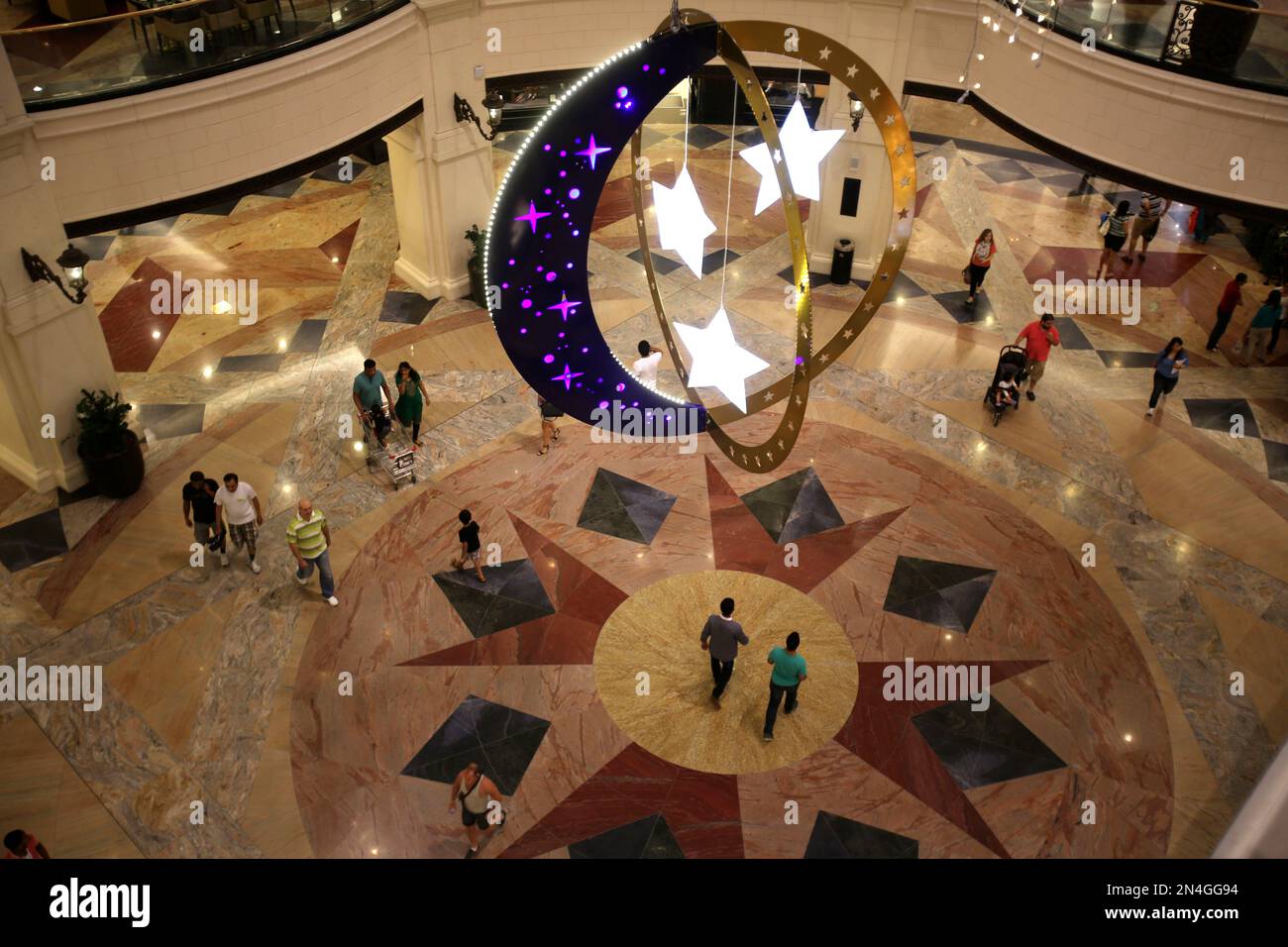 People walk inside a shopping mall with Ramadan decorations as they ...
