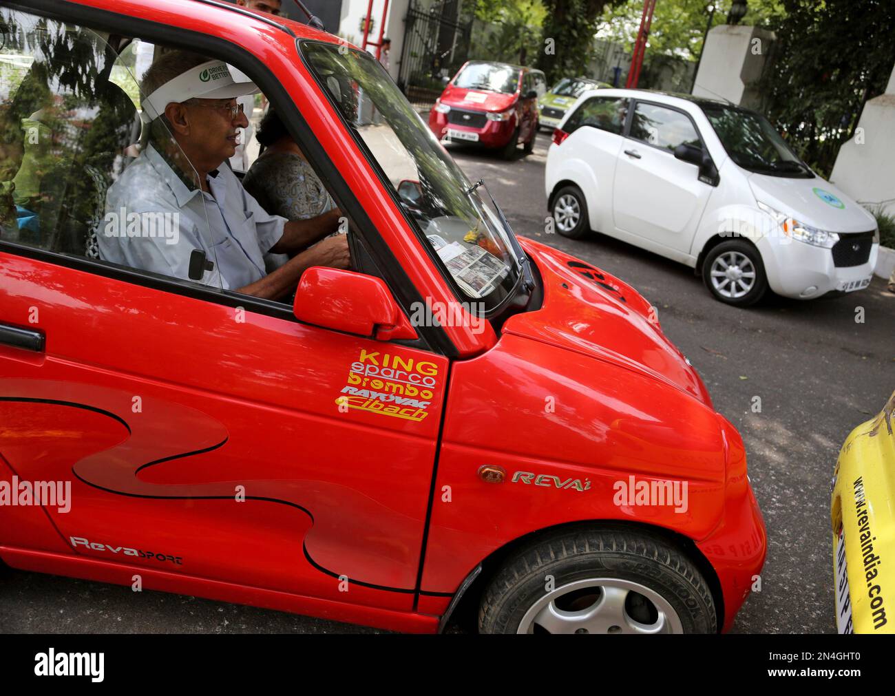 An Indian man drives a Mahindra Reva electric car during a rally ...