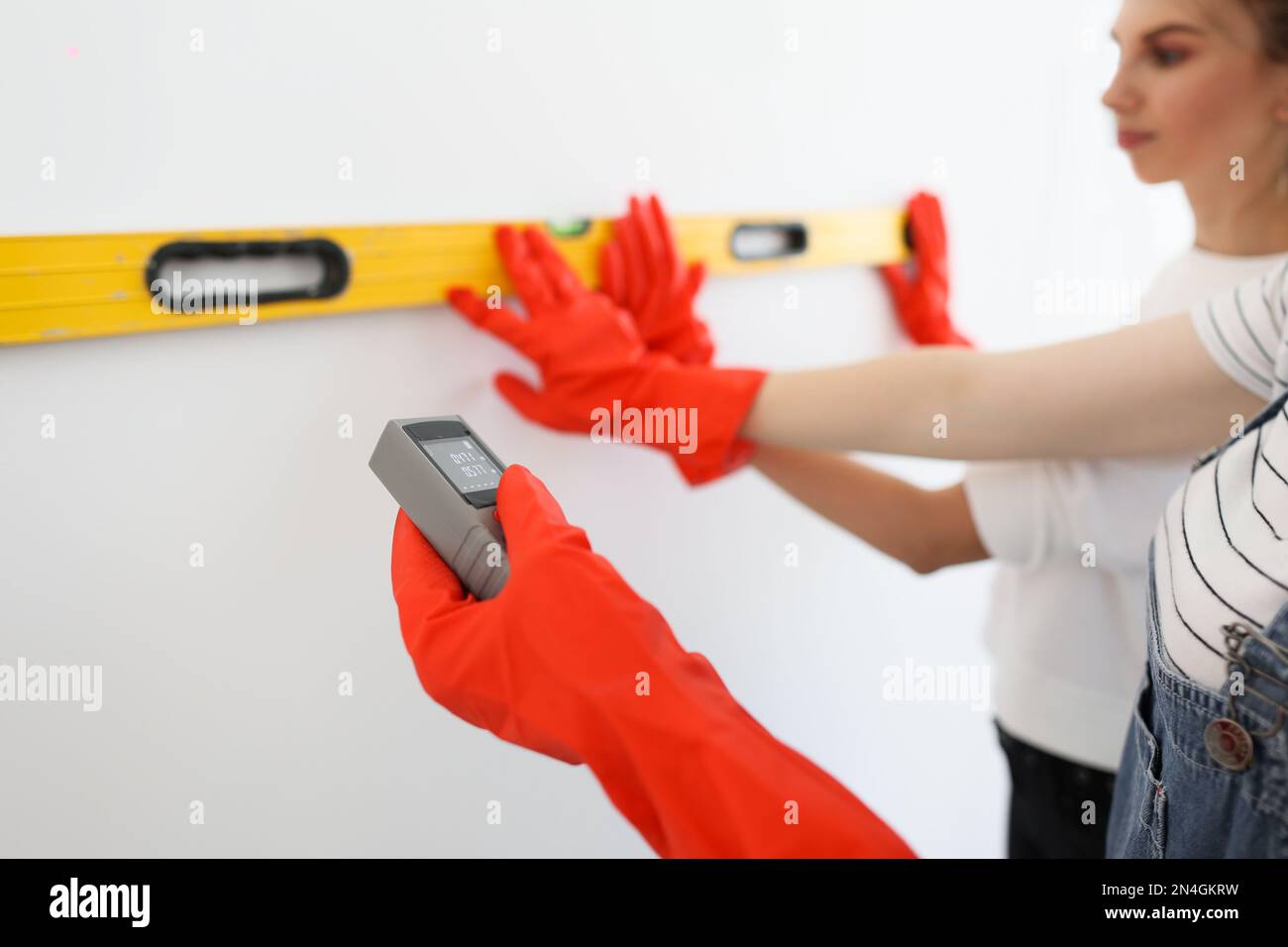 Laser rangefinder or laser tape measure in a female hand. Smart device ...