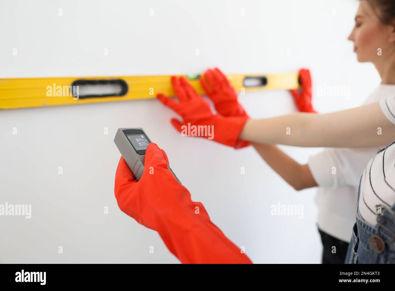 Laser rangefinder or laser tape measure in a female hand. Smart device ...