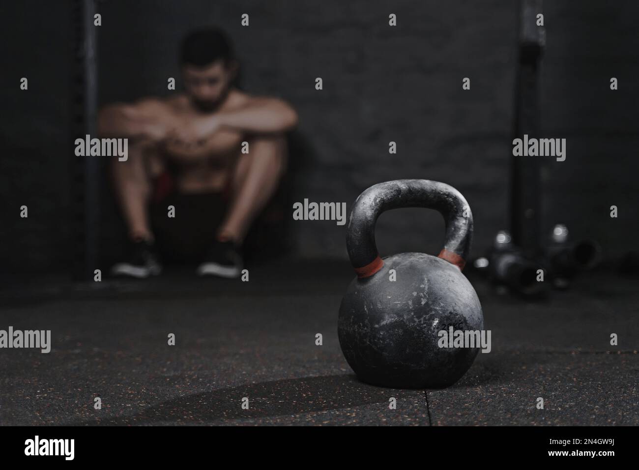 Sporty man sitting at the gym suffering breakdown to overcome ...