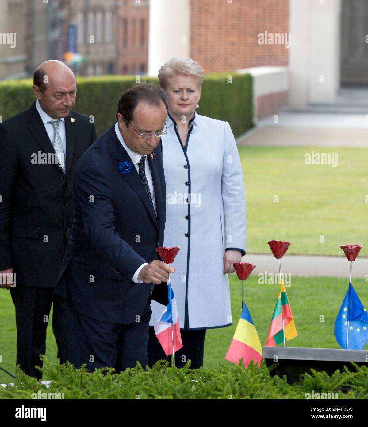 French President Francois Hollande, center, places a porcelain poppy ...