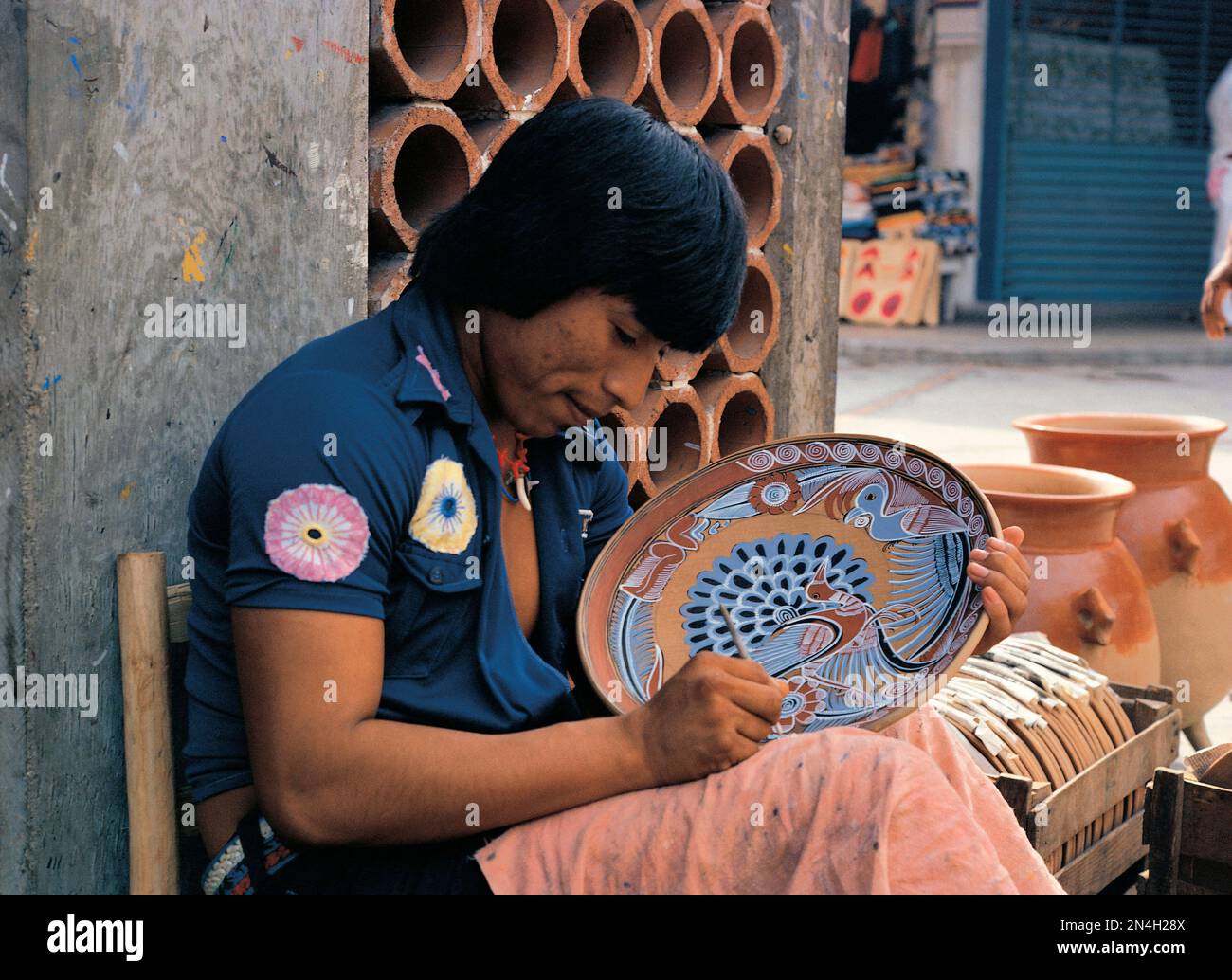 Mexico. Side view of a craft worker painting pottery plate Stock Photo ...