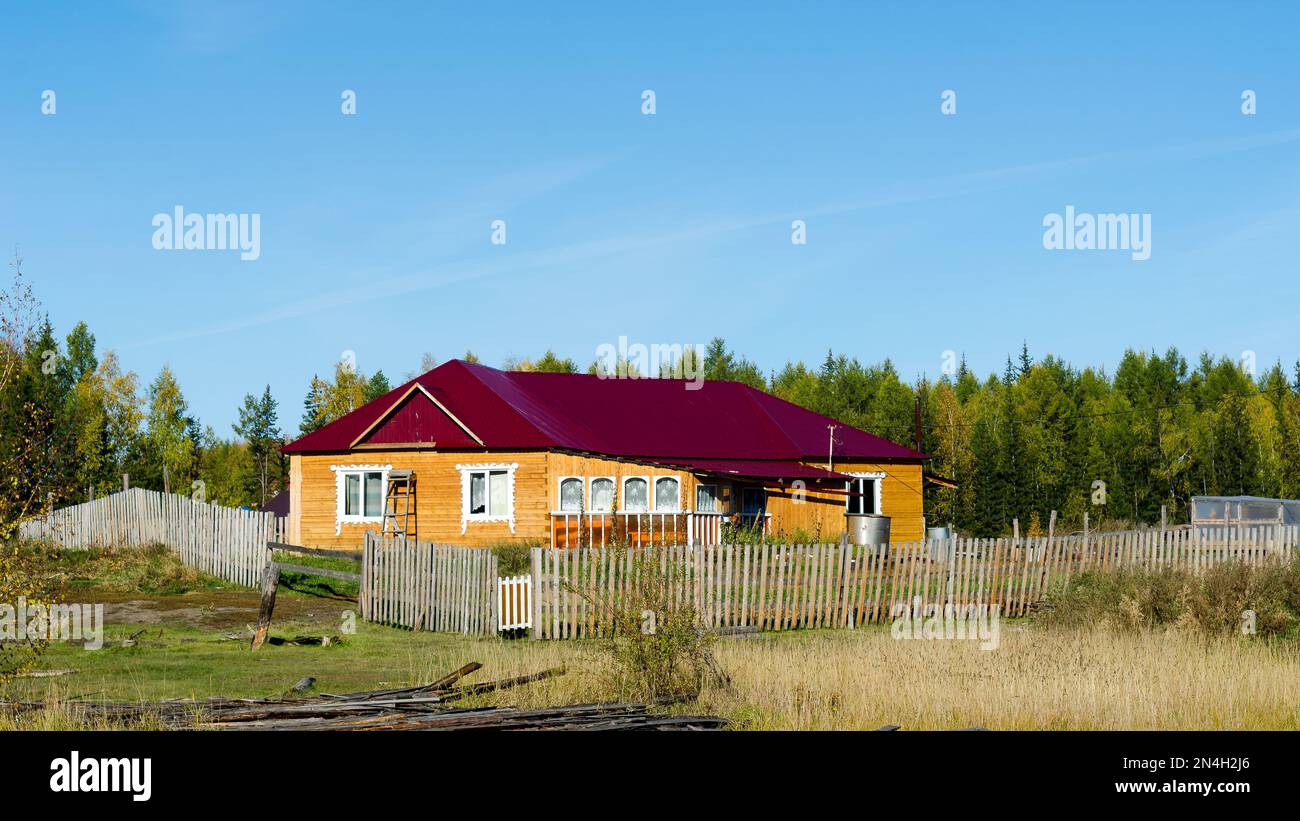 New private house made of wood with a red roof is behind a fence at the ...