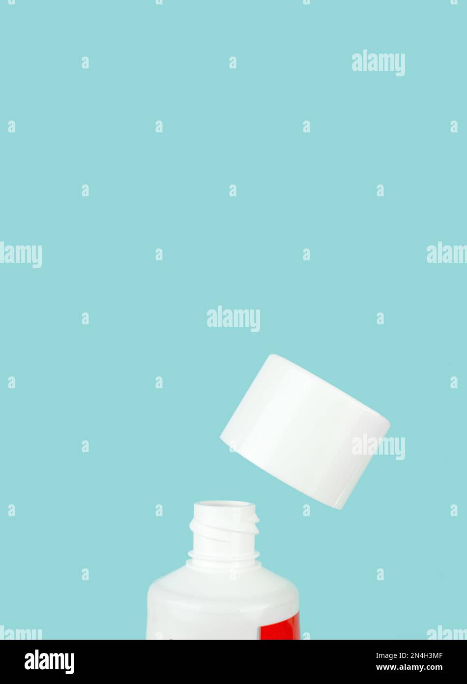 Small Red Toothpaste Tube with open lid on blue background. Means to ...