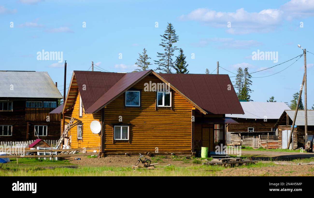 A new private cottage of yellow logs, among the old village houses, is ...