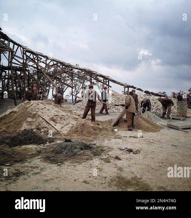 North Korean soldiers work on a mountaintop ski slope construction site ...
