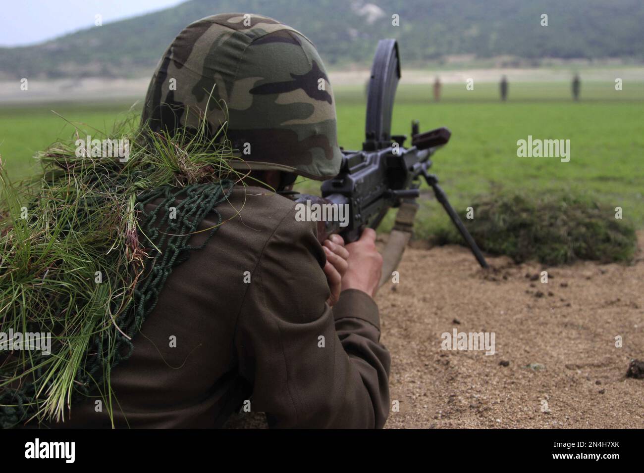 A Korean People's Army (KPA) soldier aims his weapon before firing ...