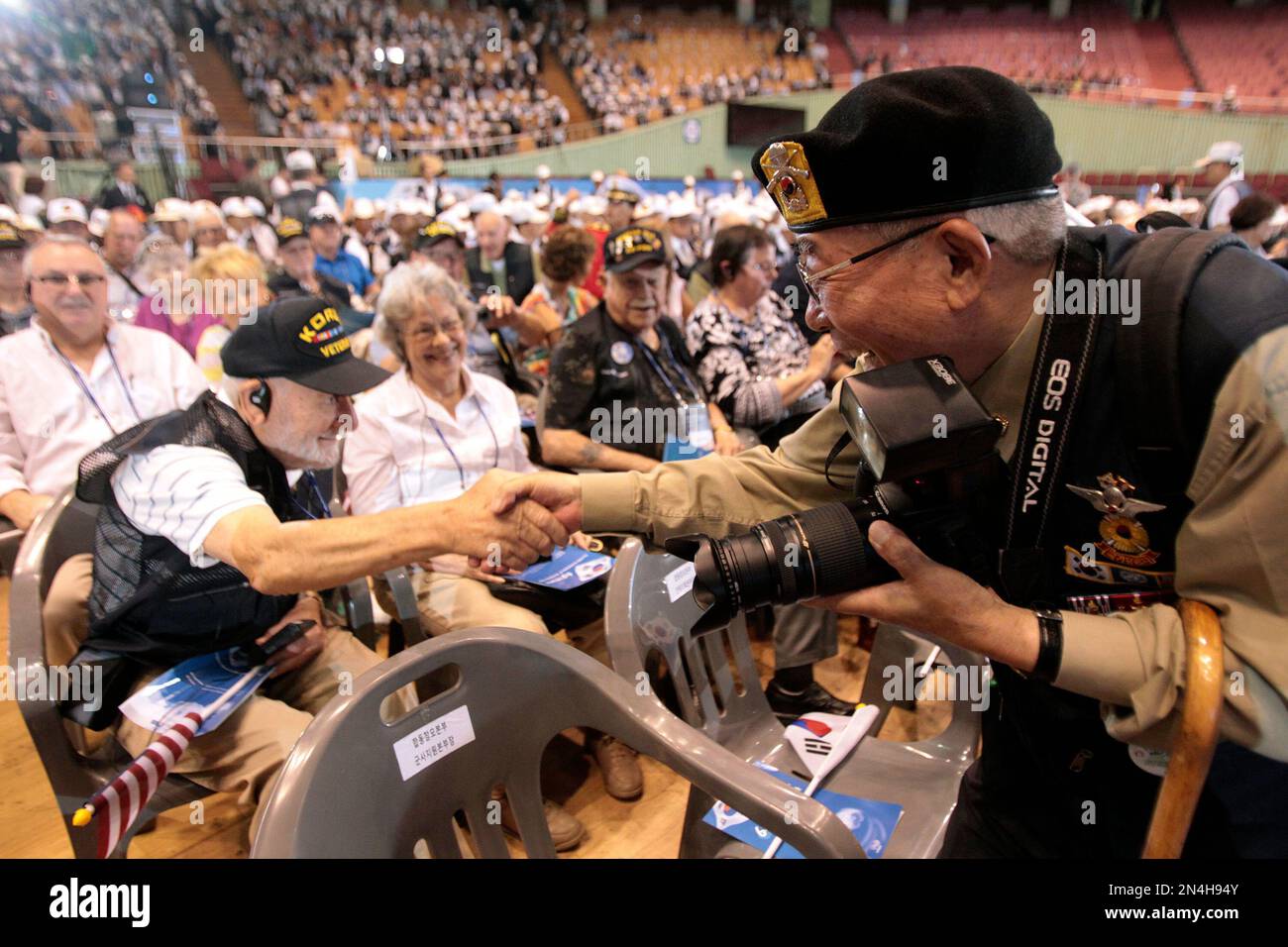 U.S. veteran Fred R. Liberhan from Brooklyn, N.Y., left, shakes hands ...