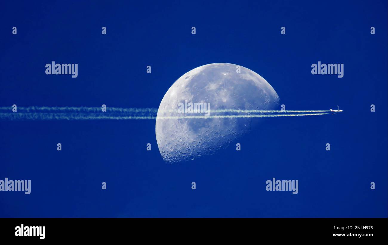 A beautiful shot of an airplane flying and leaving a trail in a blue ...