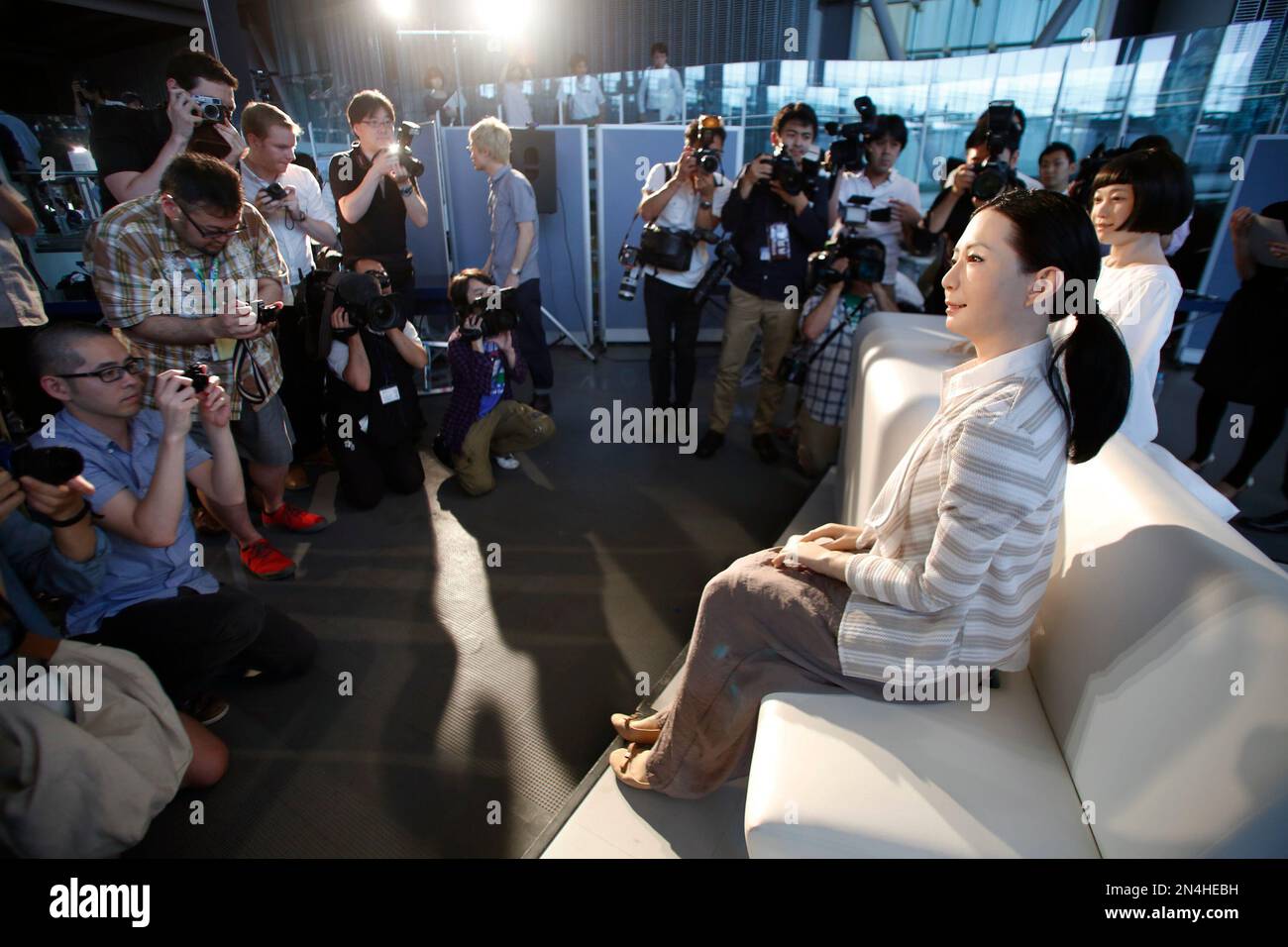 Photographers gather around to take photos of a female-announcer robot ...