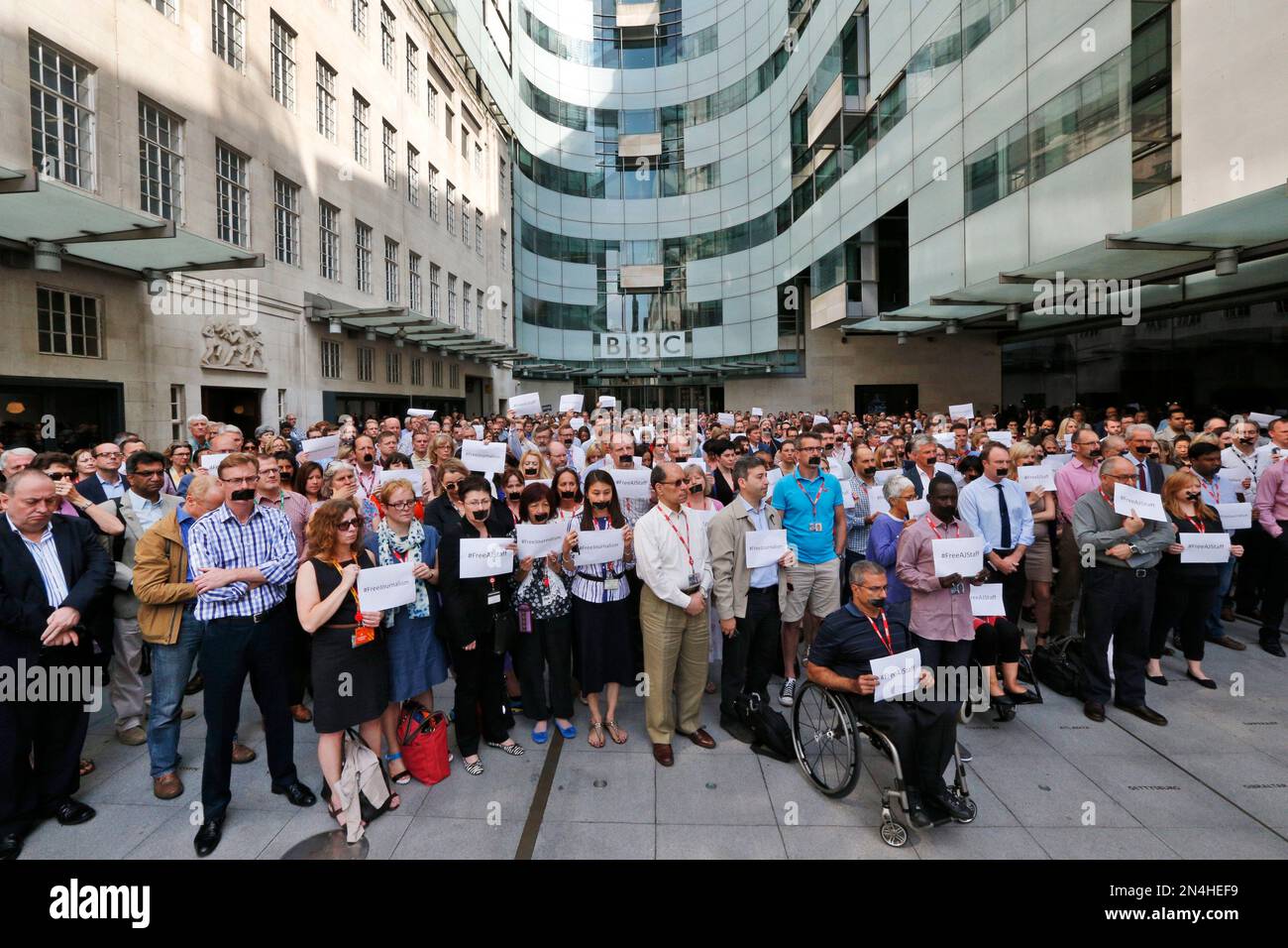 BBC journalists and staff, some with black tape over their mouths to ...