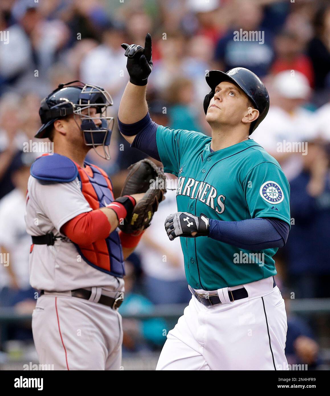 Seattle Mariners' Logan Morrison, right, points skyward as he crosses ...