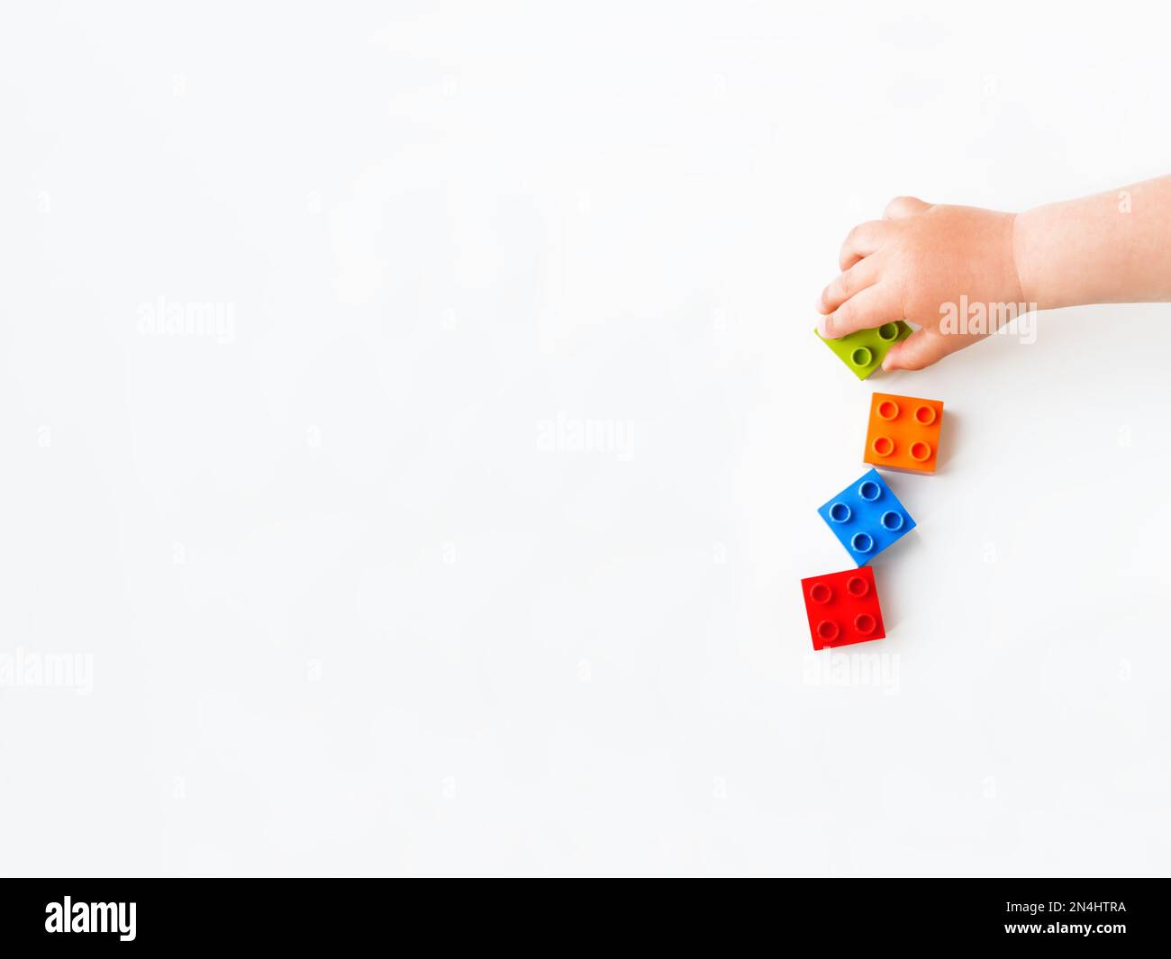 Child is playing with colorful constructor blocks. Kid's hands with ...
