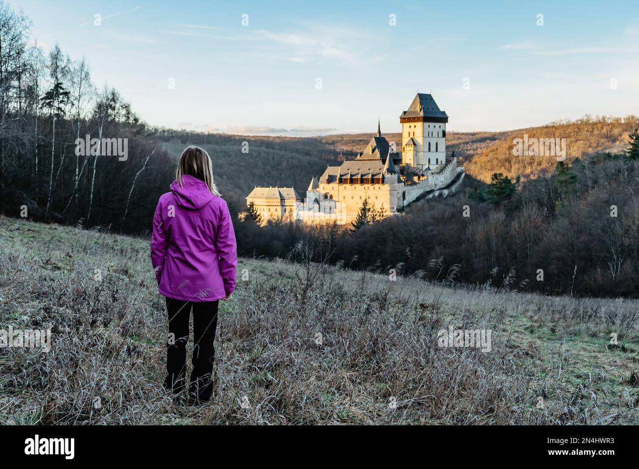 Woman tourist outdoors looking at beautiful gothic Royal Karlstejn ...