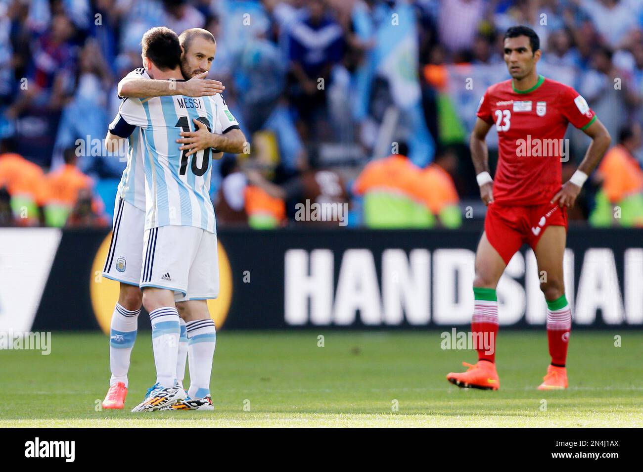 Iran's Mehrdad Pooladi watches as Argentina's Rodrigo Palacio hugs ...