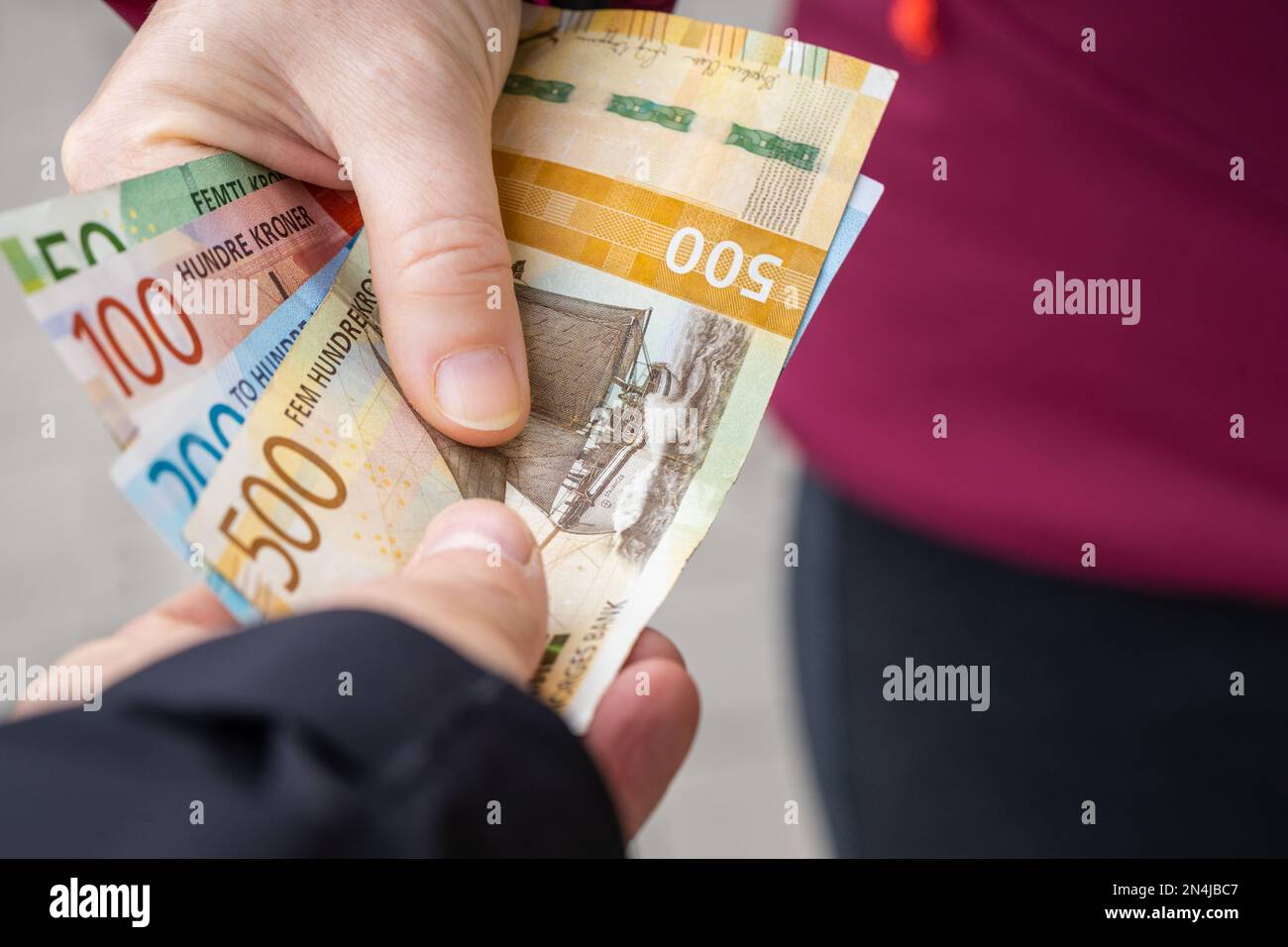 Norwegian money passing from hand to hand, Giving Norwegian kroner ...