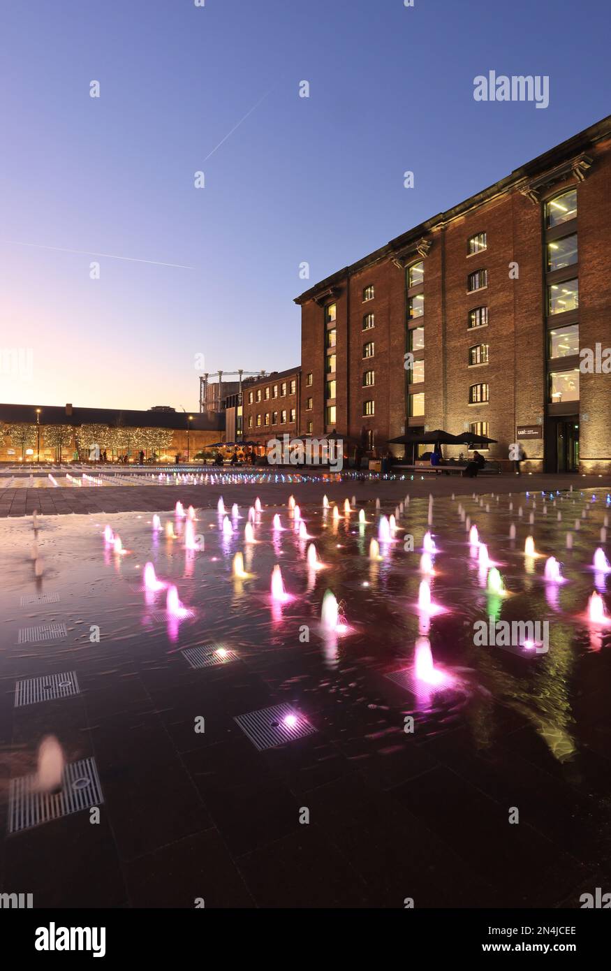 Coloured fountains in Granary Square at dusk in winter weather, at ...