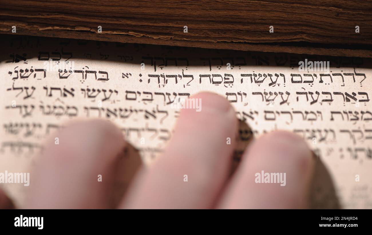 Fingers on page of old book Torah. Selective focus on snippet Hebrew ...