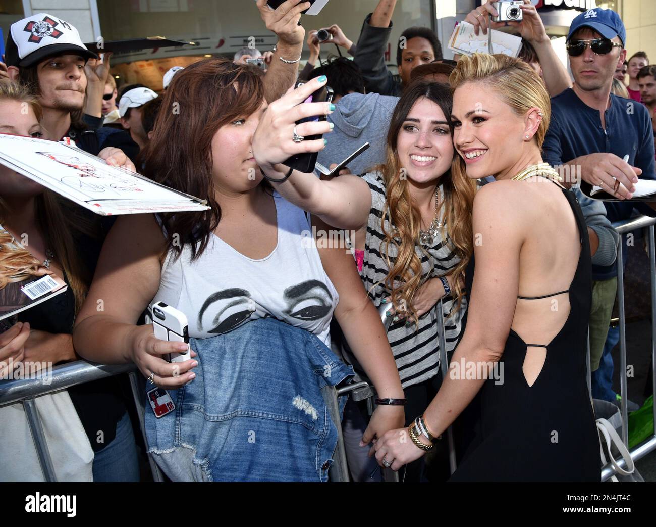 Anna Paquin, right, takes a photo with fans as she arrives at the Los ...