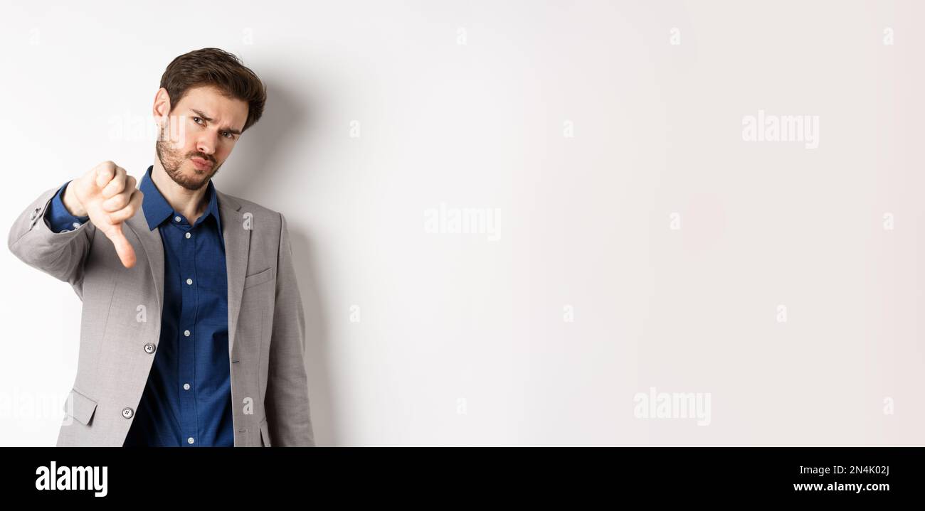 Negative emotions. Disappointed businessman frowning, showing thumb ...