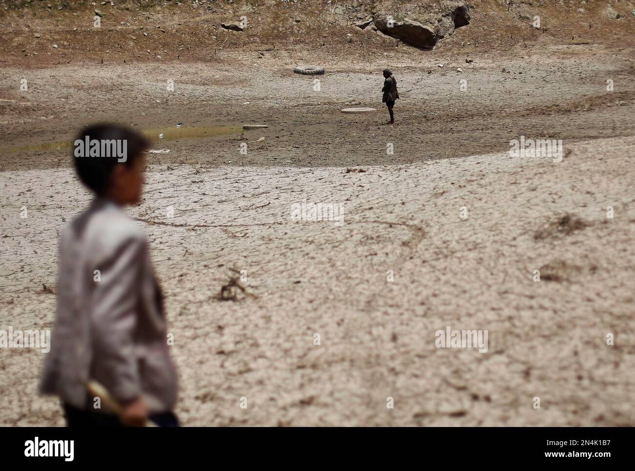 A Yemeni man inspects a drought-affected dam on the outskirts of Sanaa ...