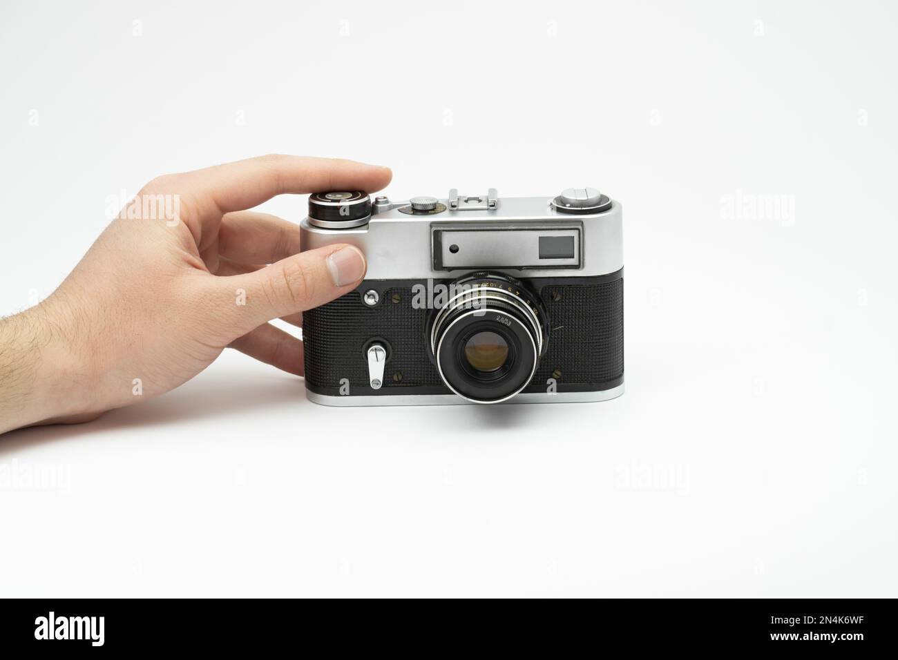 Hand pressing the shoot button on a vintage film camera isolated on ...