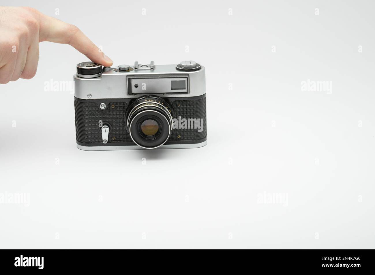 Hand pressing the shoot button on a vintage film camera isolated on ...