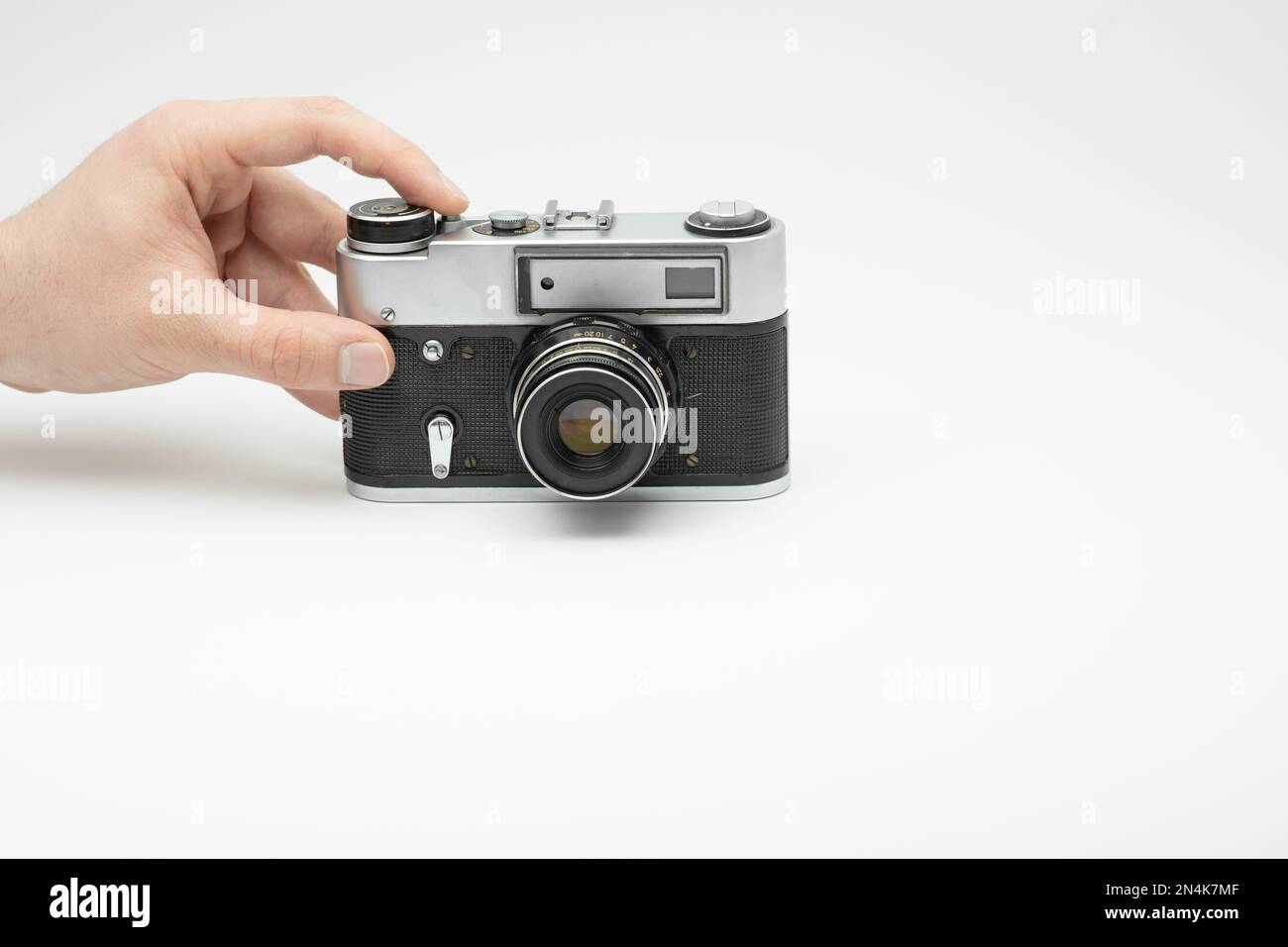 Hand pressing the shoot button on a vintage film camera isolated on ...