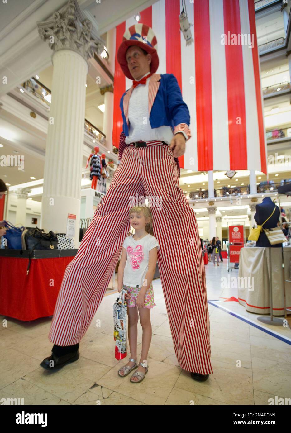 Stilt walker John Scheurich, from Chicago, steps over 6-year-old Maria ...