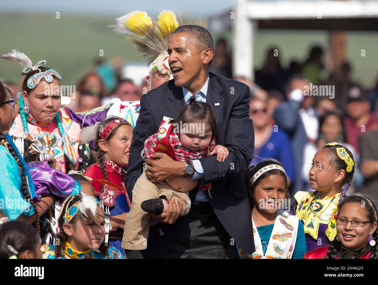 President Barack Obama holds a native American baby as he joins the ...