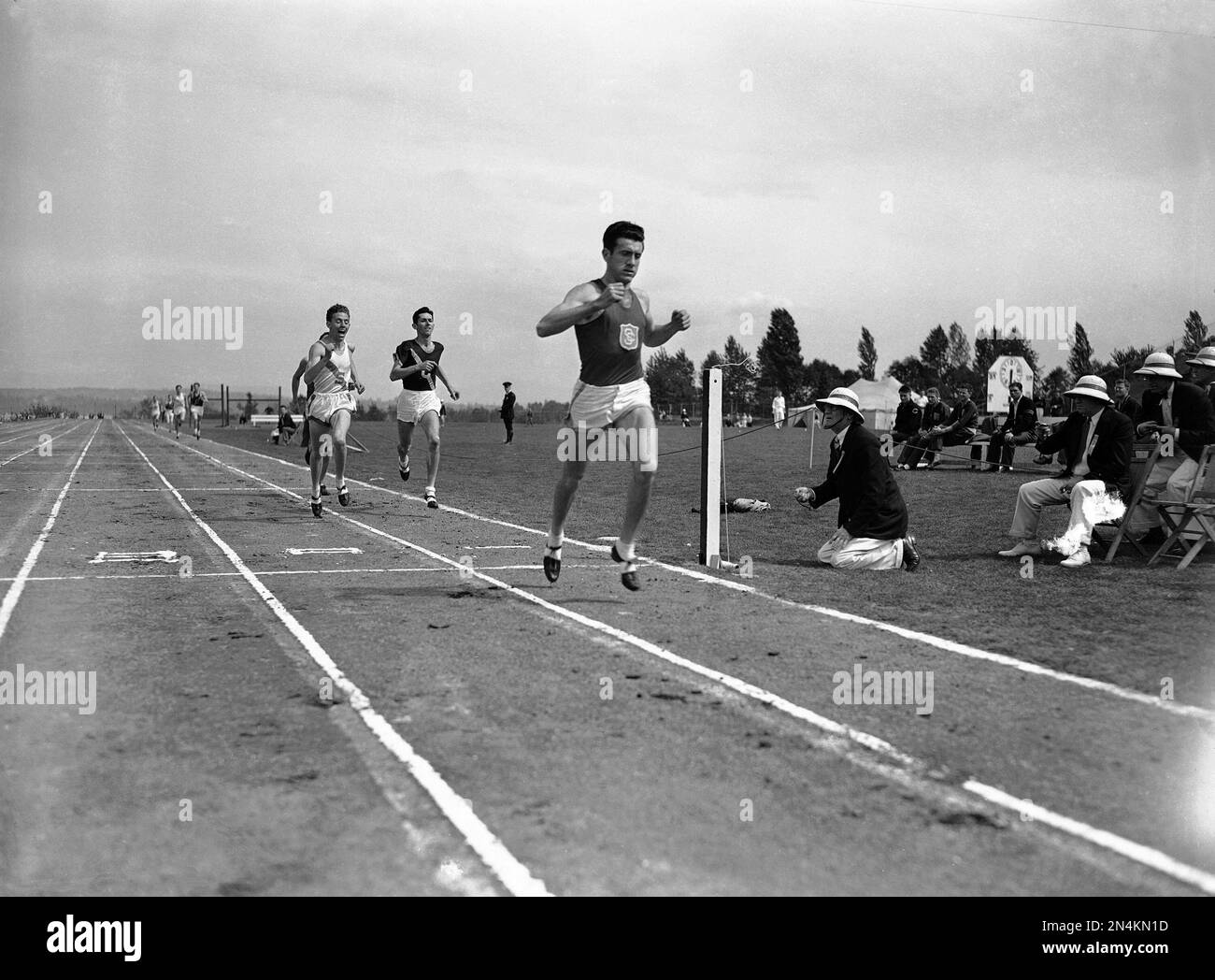 Louis Zamperini of he University of Southern California, breaks the ...