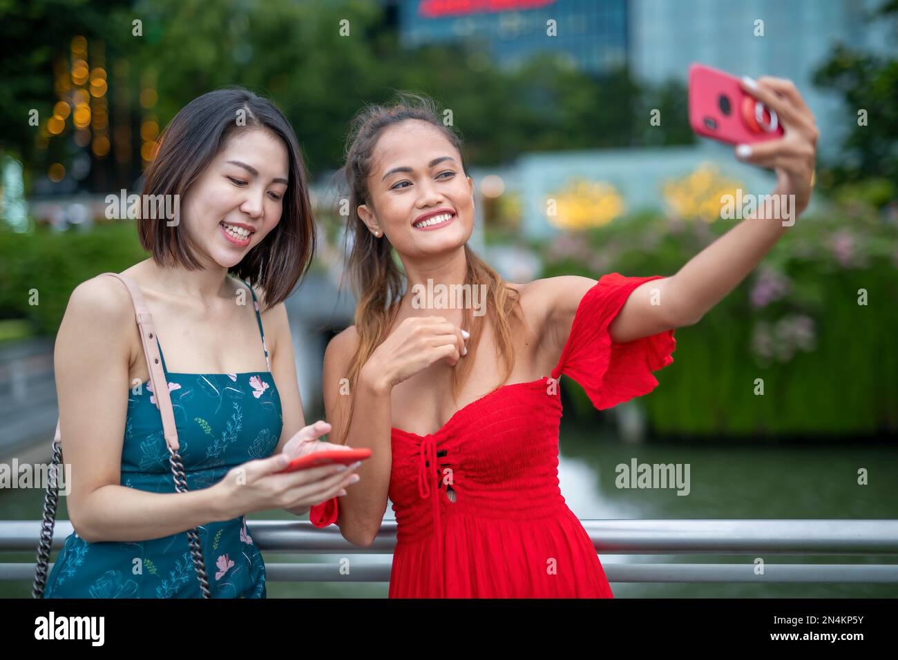 Two Happy Asian Women Taking Selfies Outdoor With The Smartphone Stock