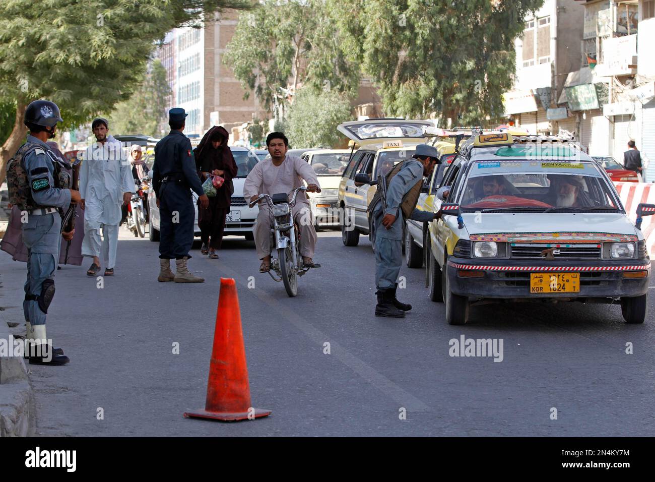 Afghanistan police search a car at a checkpoint in Kandahar, south of ...